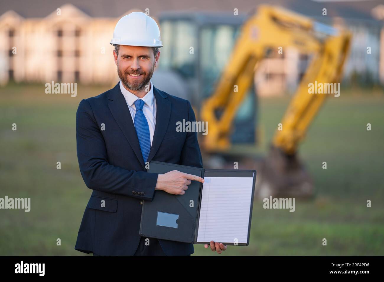 Architect at a construction site. Architect man in helmet and suit at ...