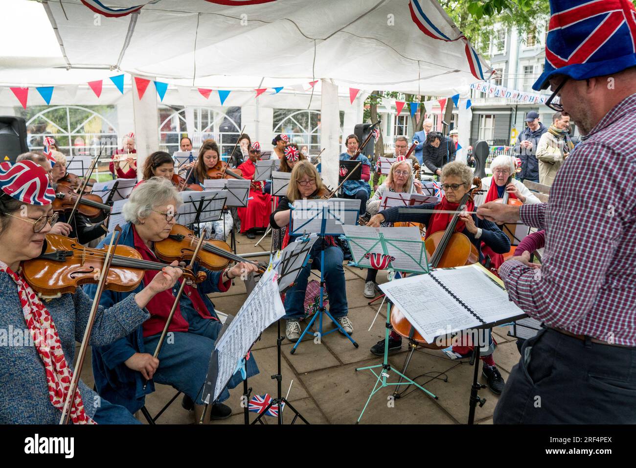 An orchestra plays at a street party in Primrose Hill London to ...