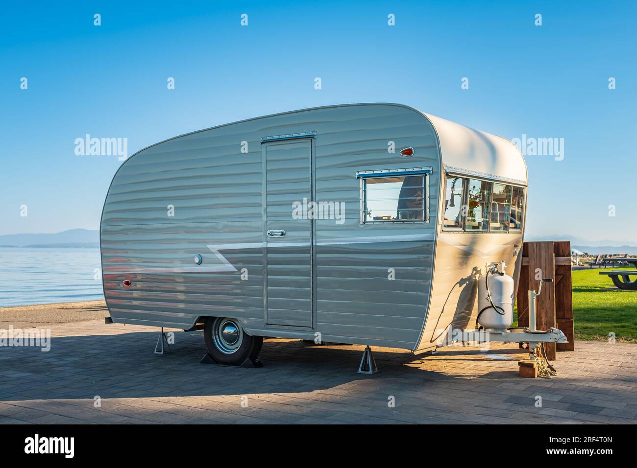 Cozy retro travel trailer Caravan before sunset near ocean or sea ...