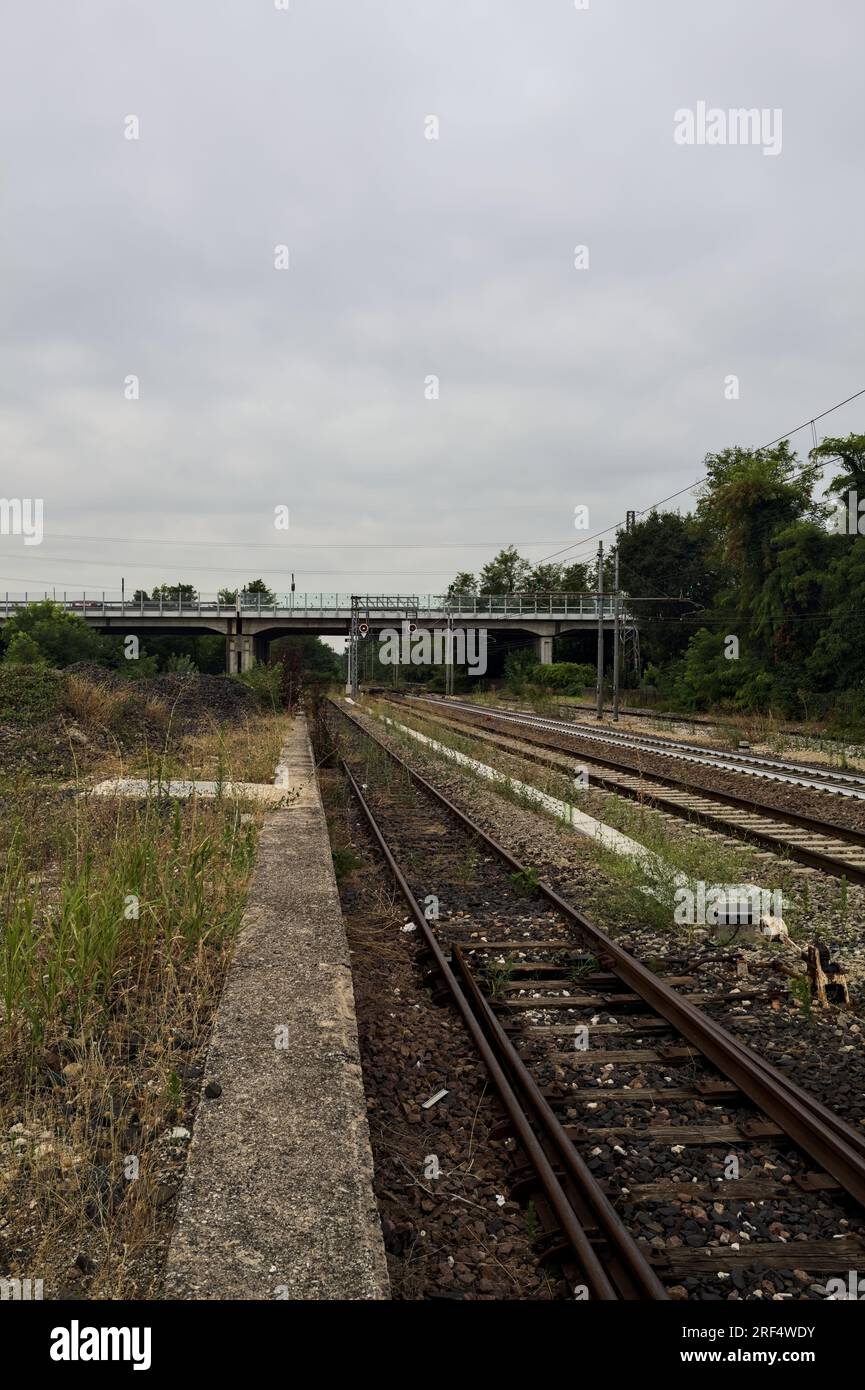 Railroad that passes under a small viaduct on a cloudy day in the ...