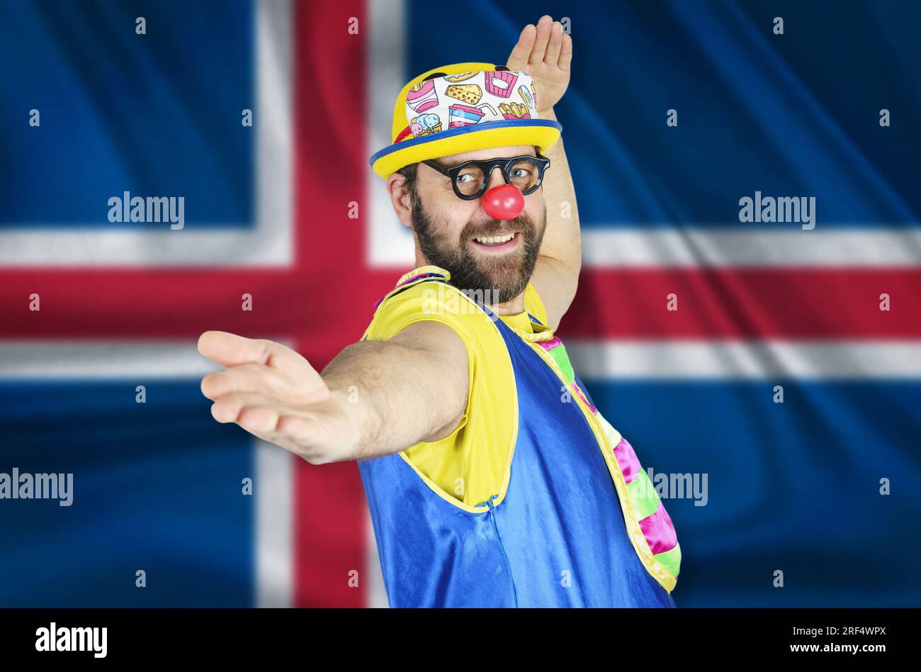 A cheerful clown stands in a welcoming pose against the background of ...
