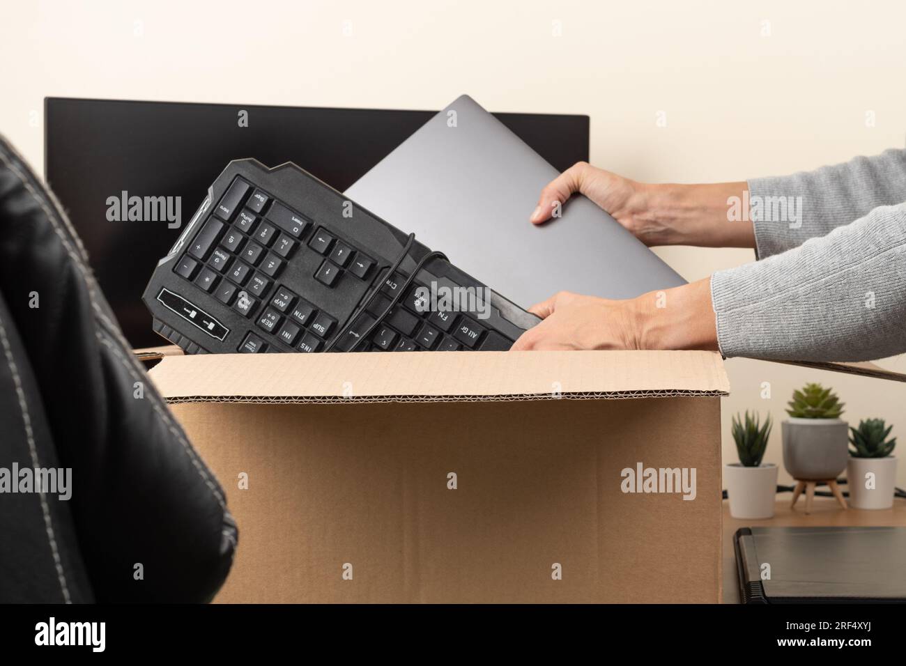 Woman hands put old laptop and keyboard in box with old used computers ...
