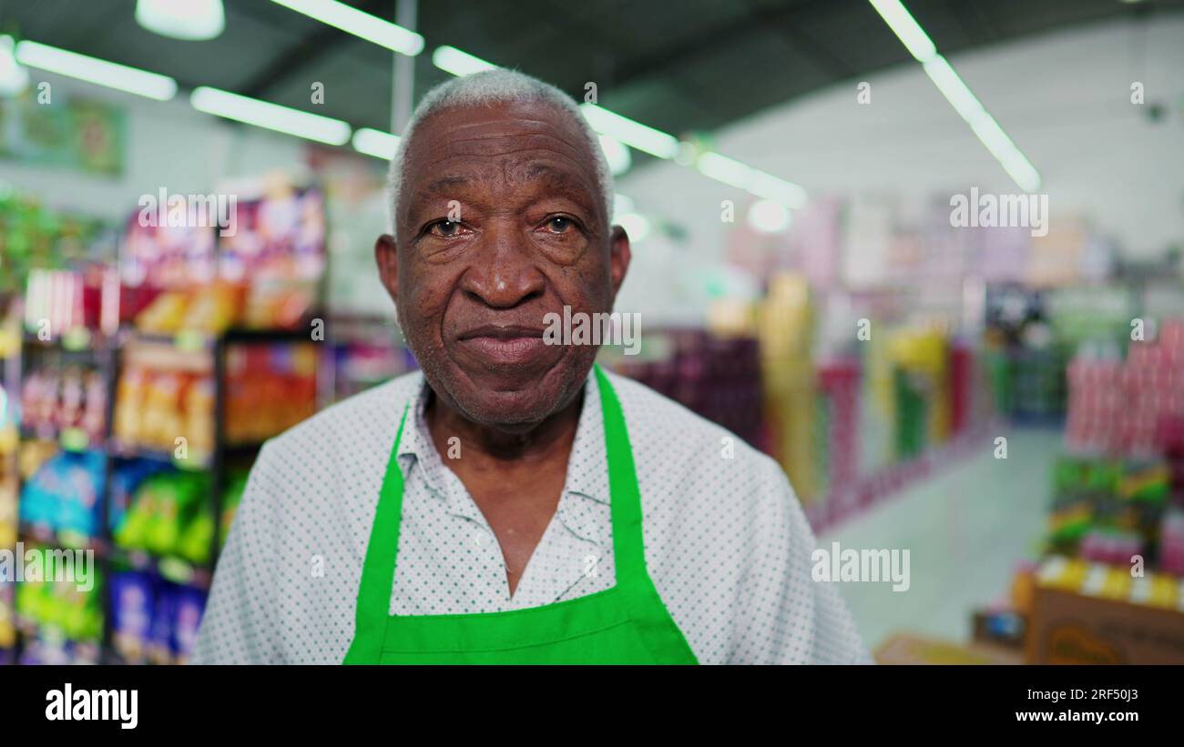 Portrait of an African American senior employee of supermarket wearing ...