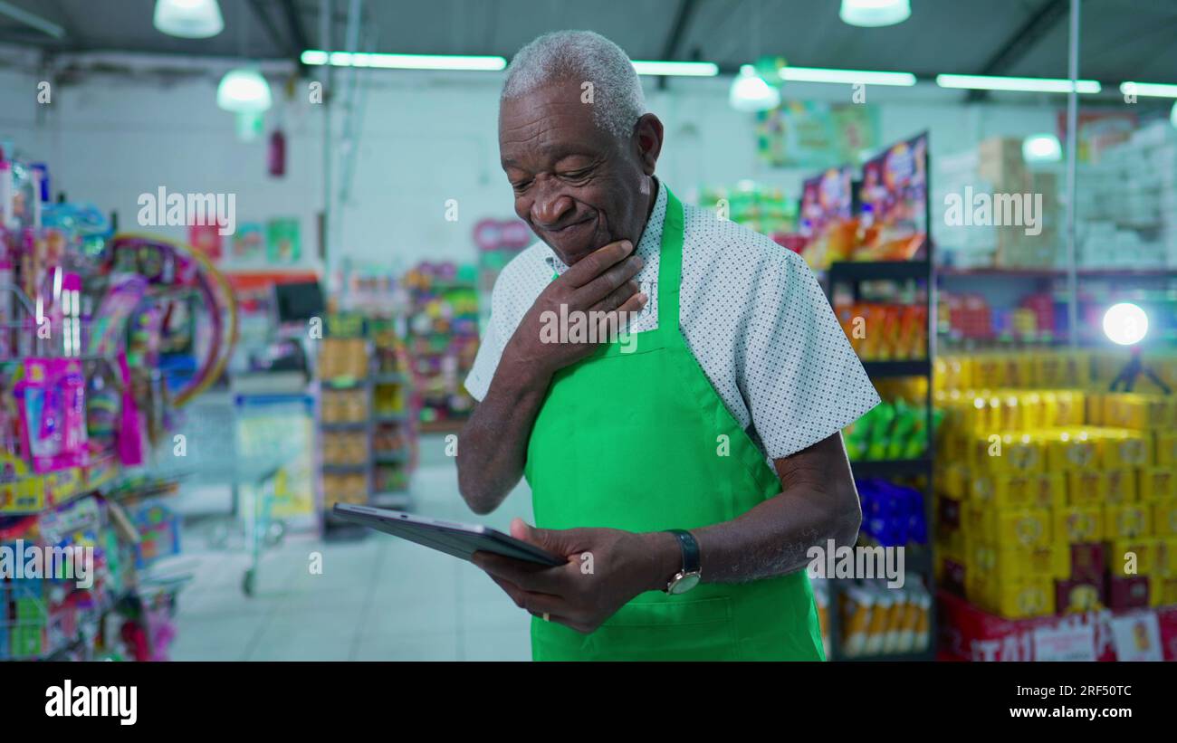 Confused Senior African American Employee with Tablet Inside Grocery ...
