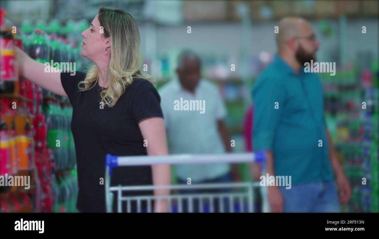 Female Consumer with Cart Navigating Supermarket Shelves, Shoppers in ...