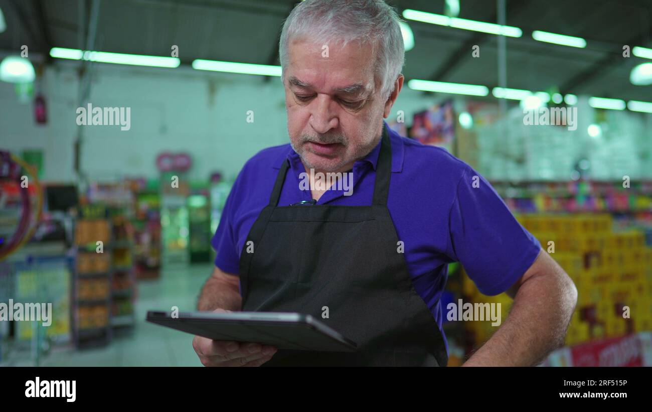 Frustrated Business owner of Supermarket holding tablet inspecting ...