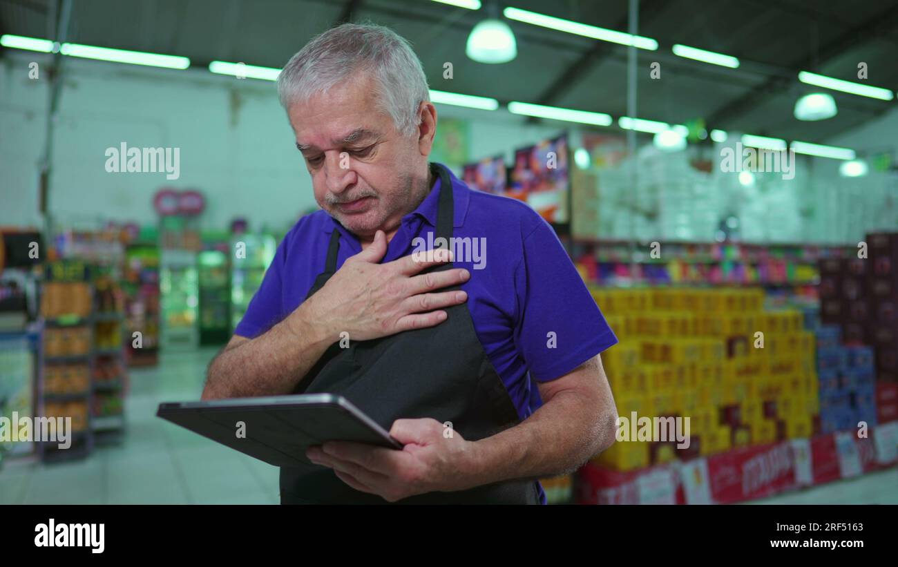 Frustrated Business owner of Supermarket holding tablet inspecting ...