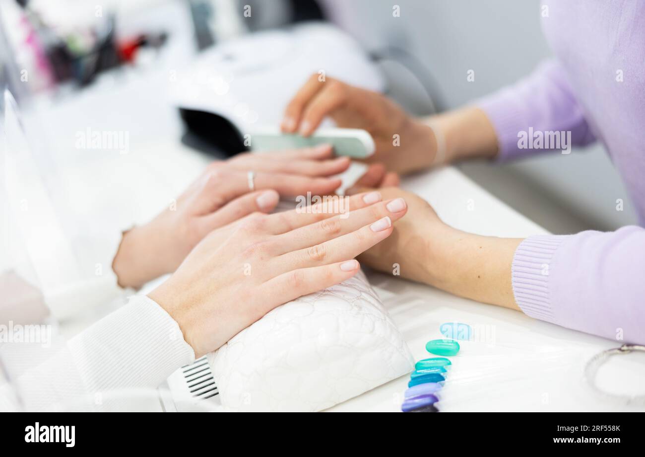 Woman performing manicure shaping hi-res stock photography and images ...