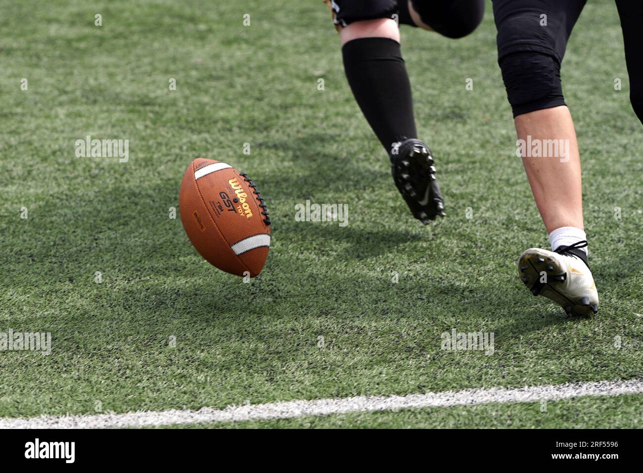 Chasing a bouncing American Football Stock Photo - Alamy