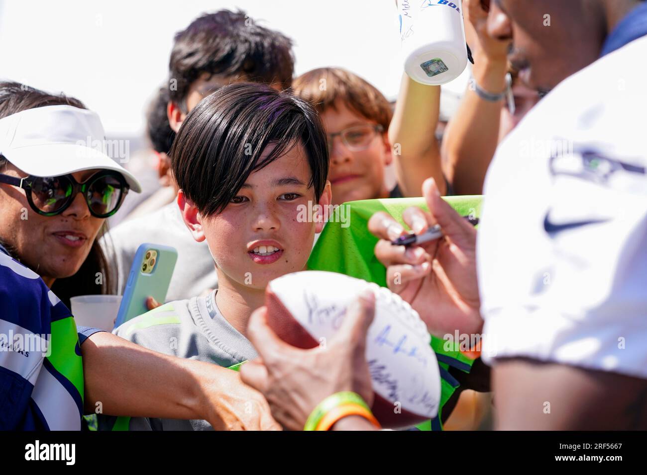 A fan watches their ball get signed by Seattle Seahawks cornerback ...