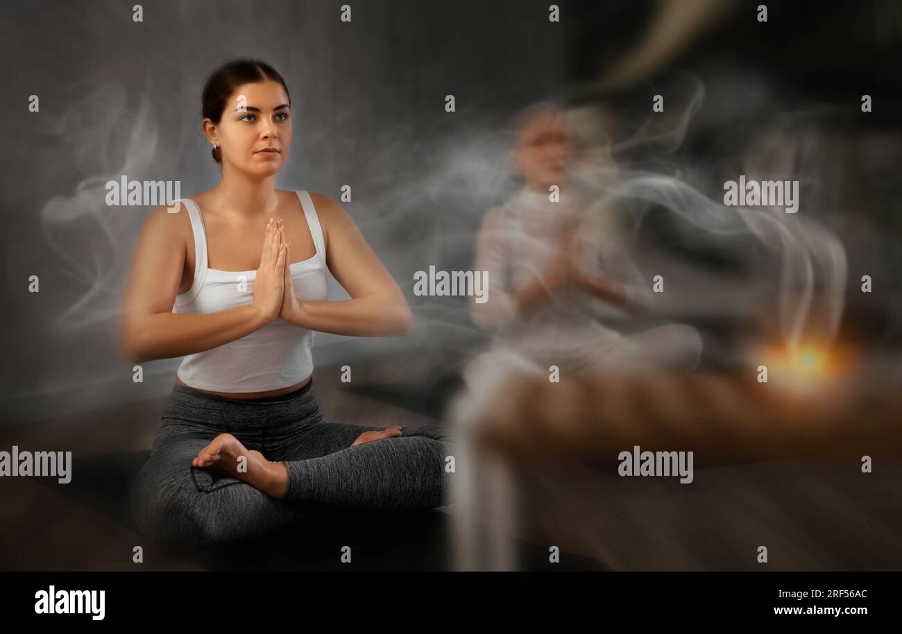Young girl sitting in Padmasana yoga position with arms in namaste ...