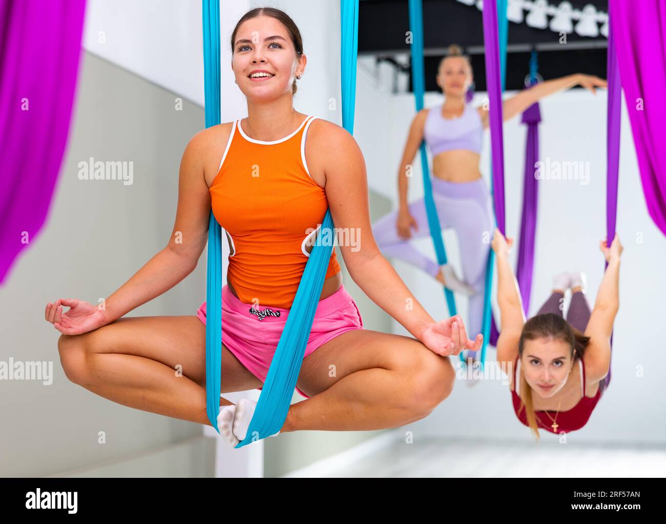 Aerial yoga in hammock. Slim woman performs gravity fly yoga and ...