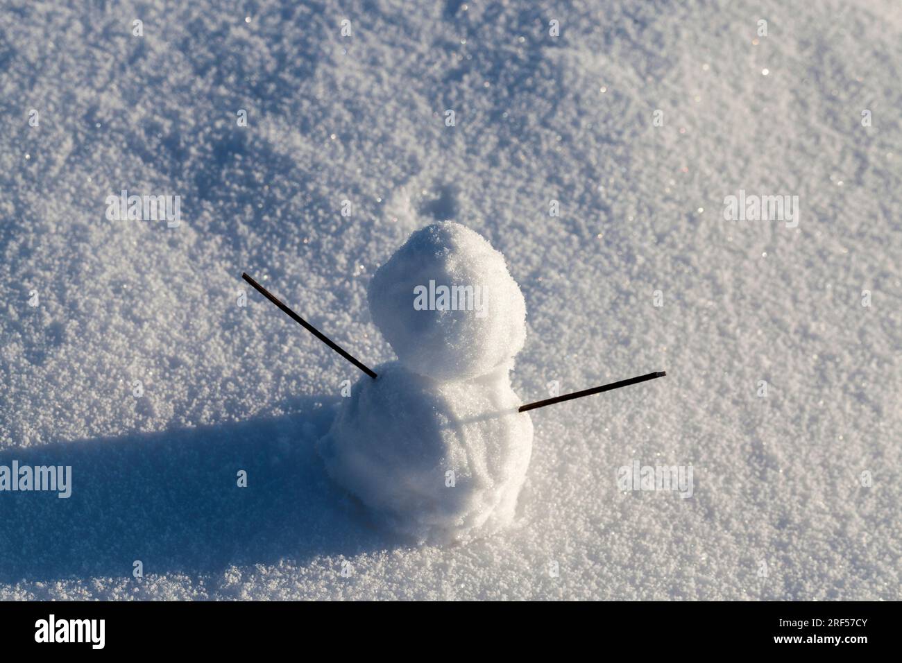 the snowman is made of several parts and stands in the snow in cold ...