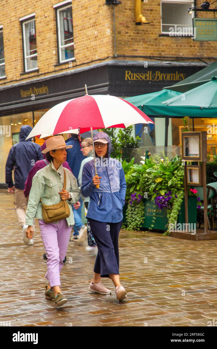 People walking and shopping in the rain, under umbrella's in the high ...