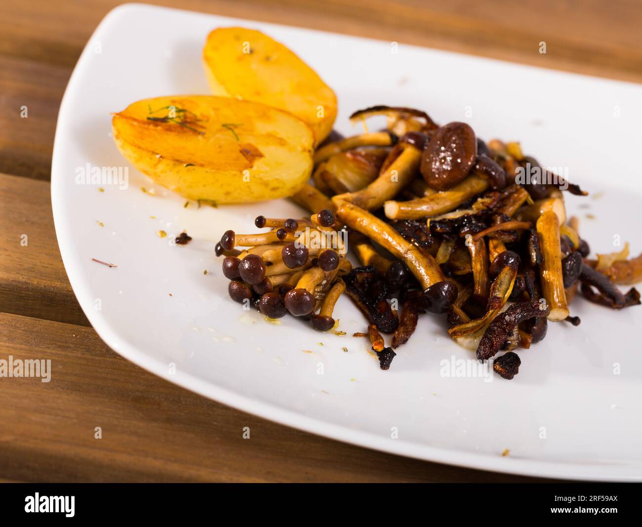 Delicious cooked fried honey fungus mushrooms with young potatoes Stock ...