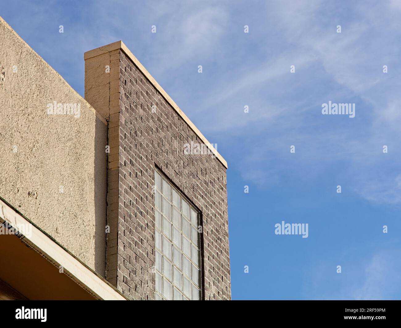Brown brick glass block and stucco facade at roofline of commercial ...