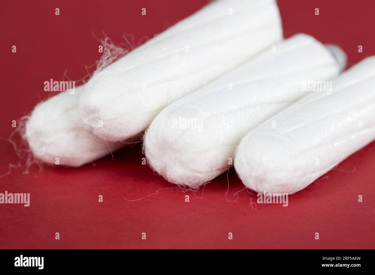 women's sanitary tampon on a red background, sanitary tampon made of ...