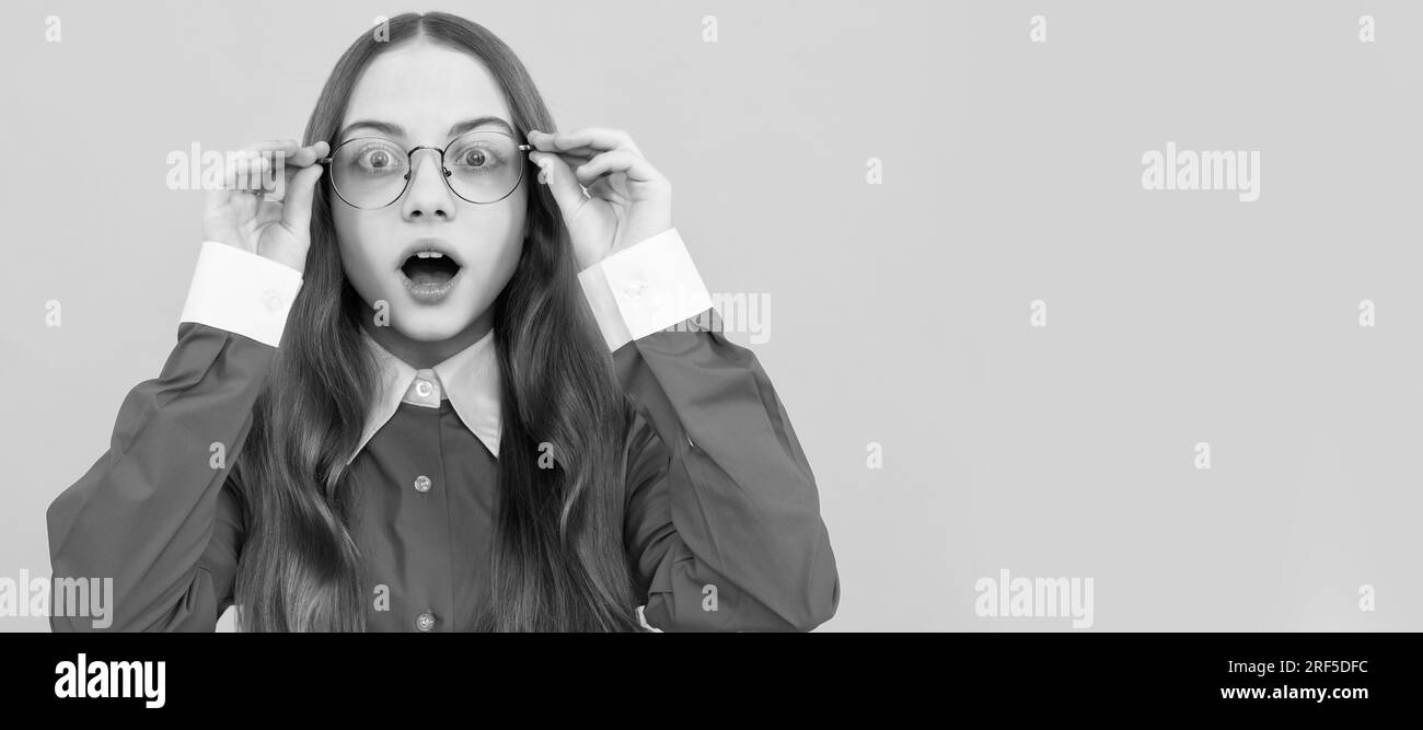Shocked school aged girl child in spectacles with amazed look yellow ...