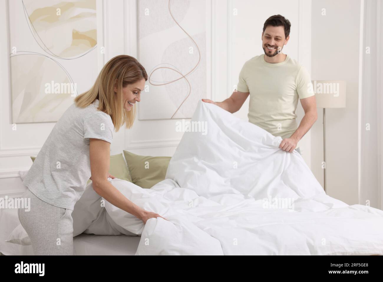 Couple changing bed linens at home. Domestic chores Stock Photo - Alamy