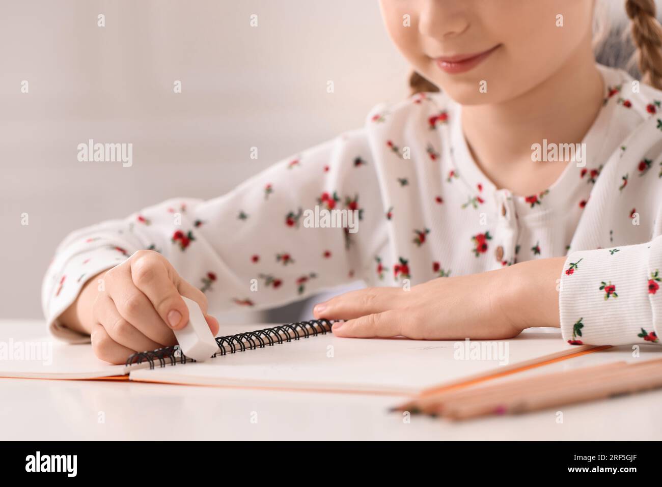 Girl using eraser at white desk, closeup Stock Photo - Alamy
