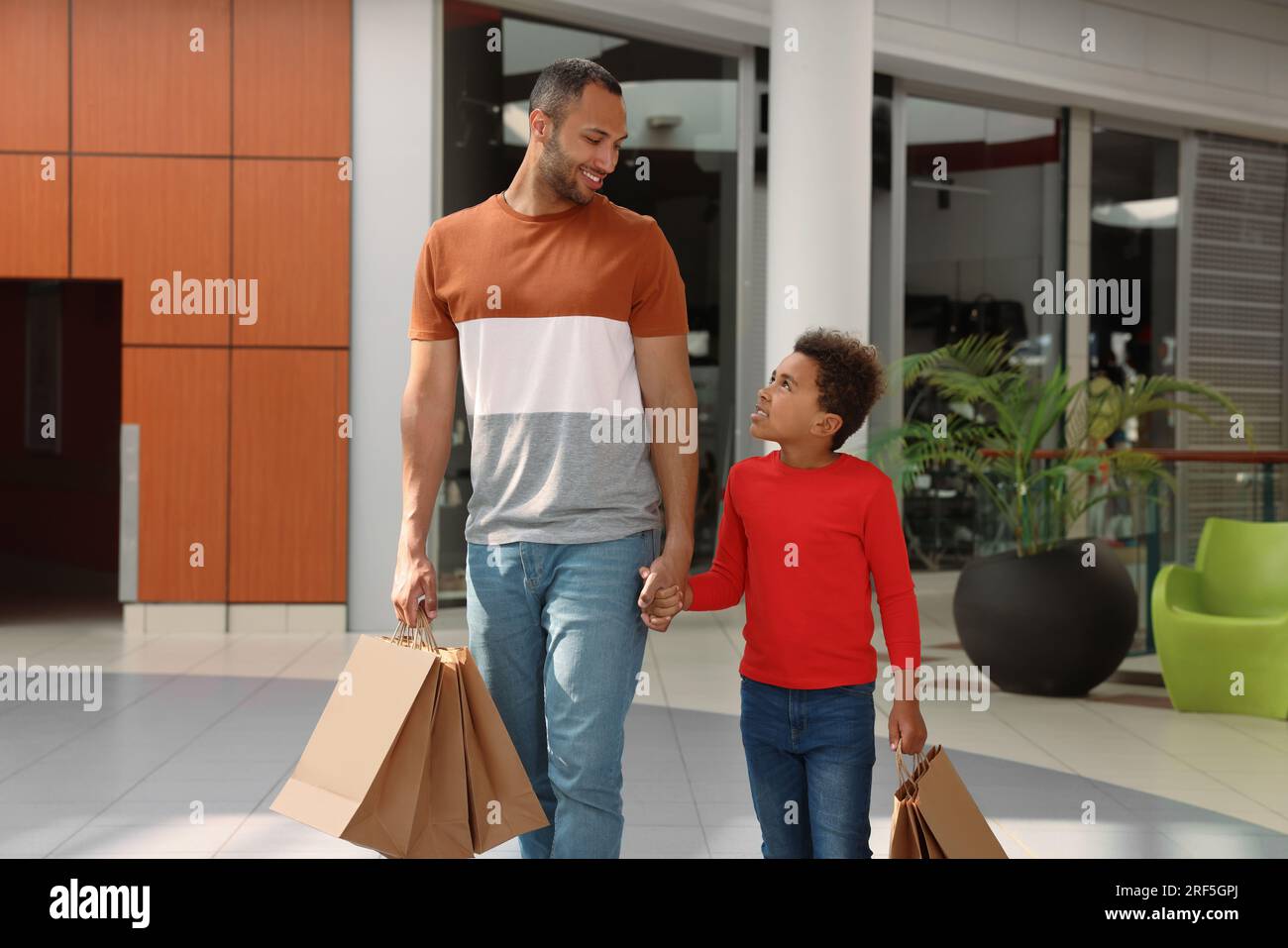 Family shopping. Happy father and son with purchases in mall Stock ...