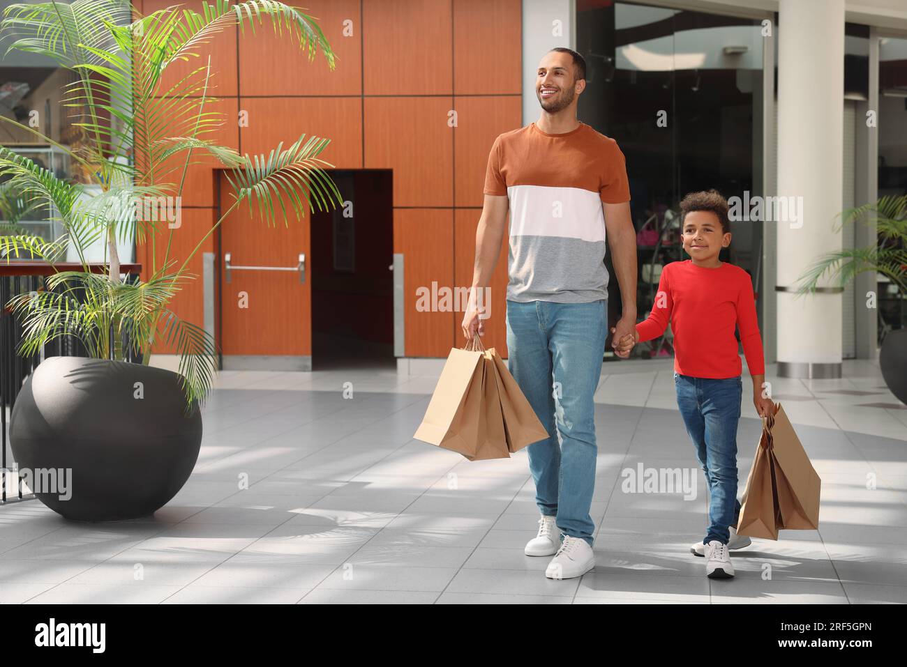 Family shopping. Happy father and son with purchases in mall Stock ...