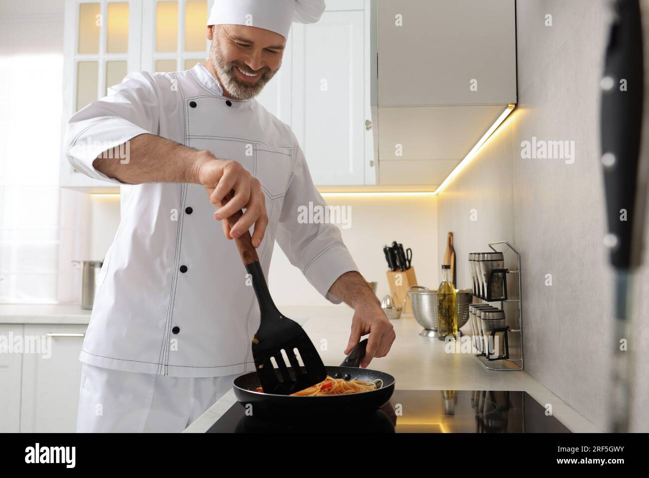 Professional chef cooking delicious pasta in kitchen Stock Photo - Alamy