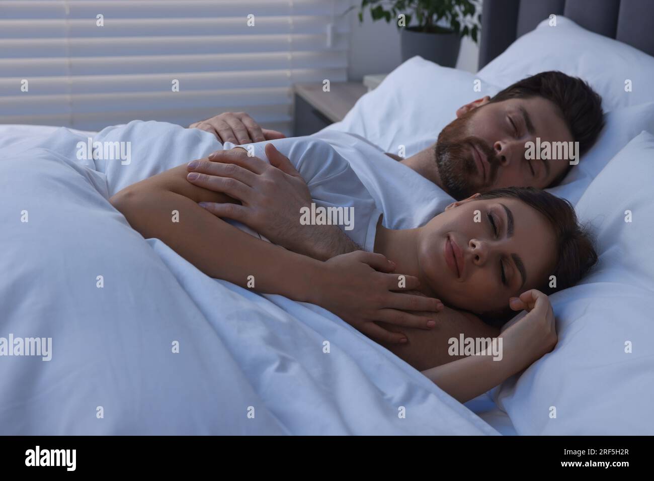 Lovely couple sleeping together in bed at night Stock Photo - Alamy