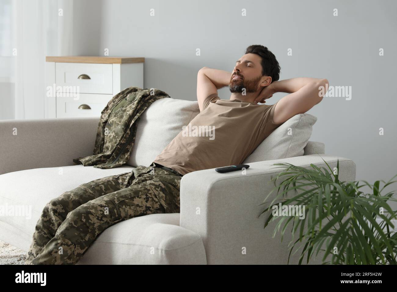 Soldier napping on soft sofa in living room. Military service Stock ...