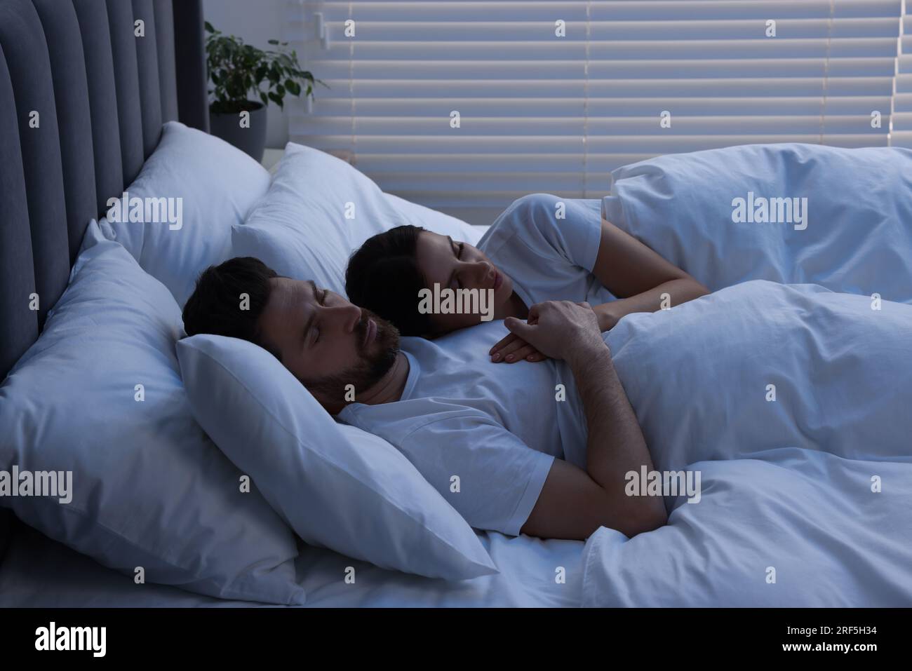 Lovely couple sleeping together in bed at night Stock Photo - Alamy