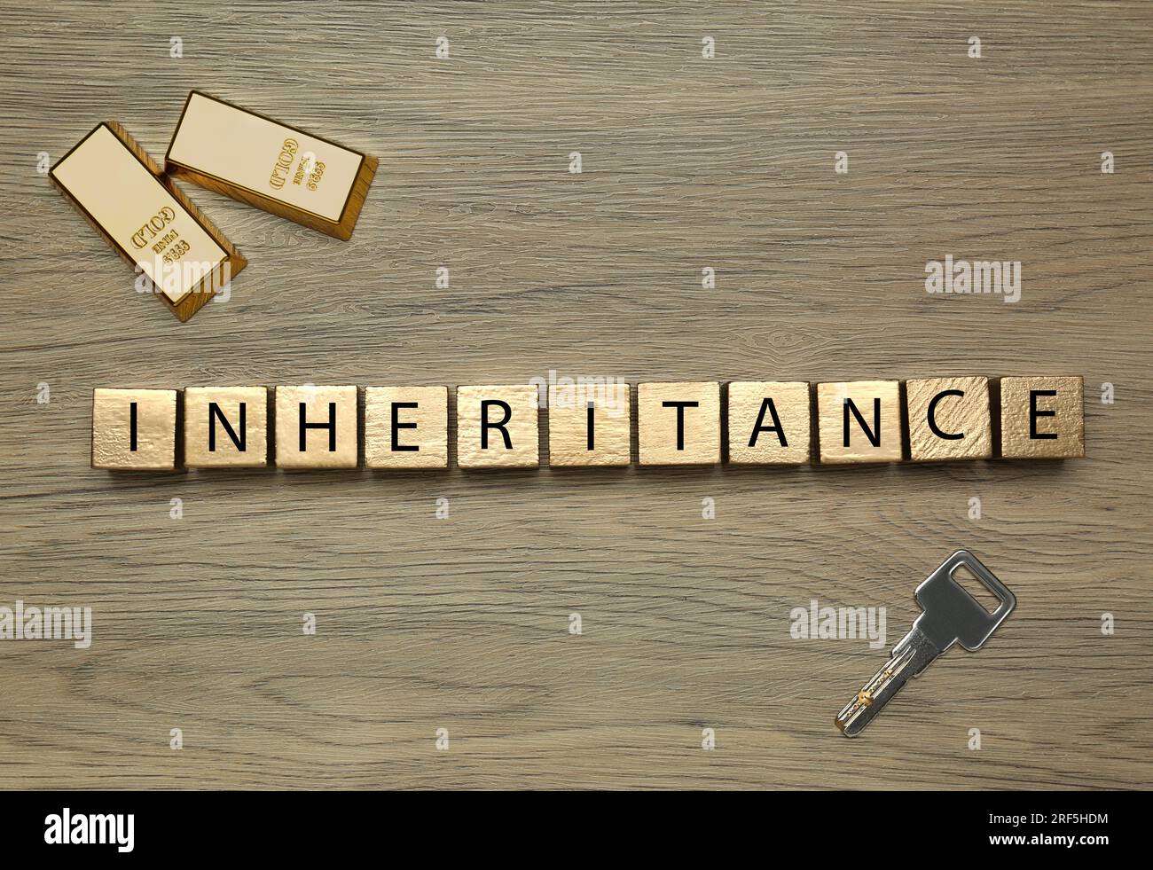 Word Inheritance made with cubes, gold bars and key on wooden table ...