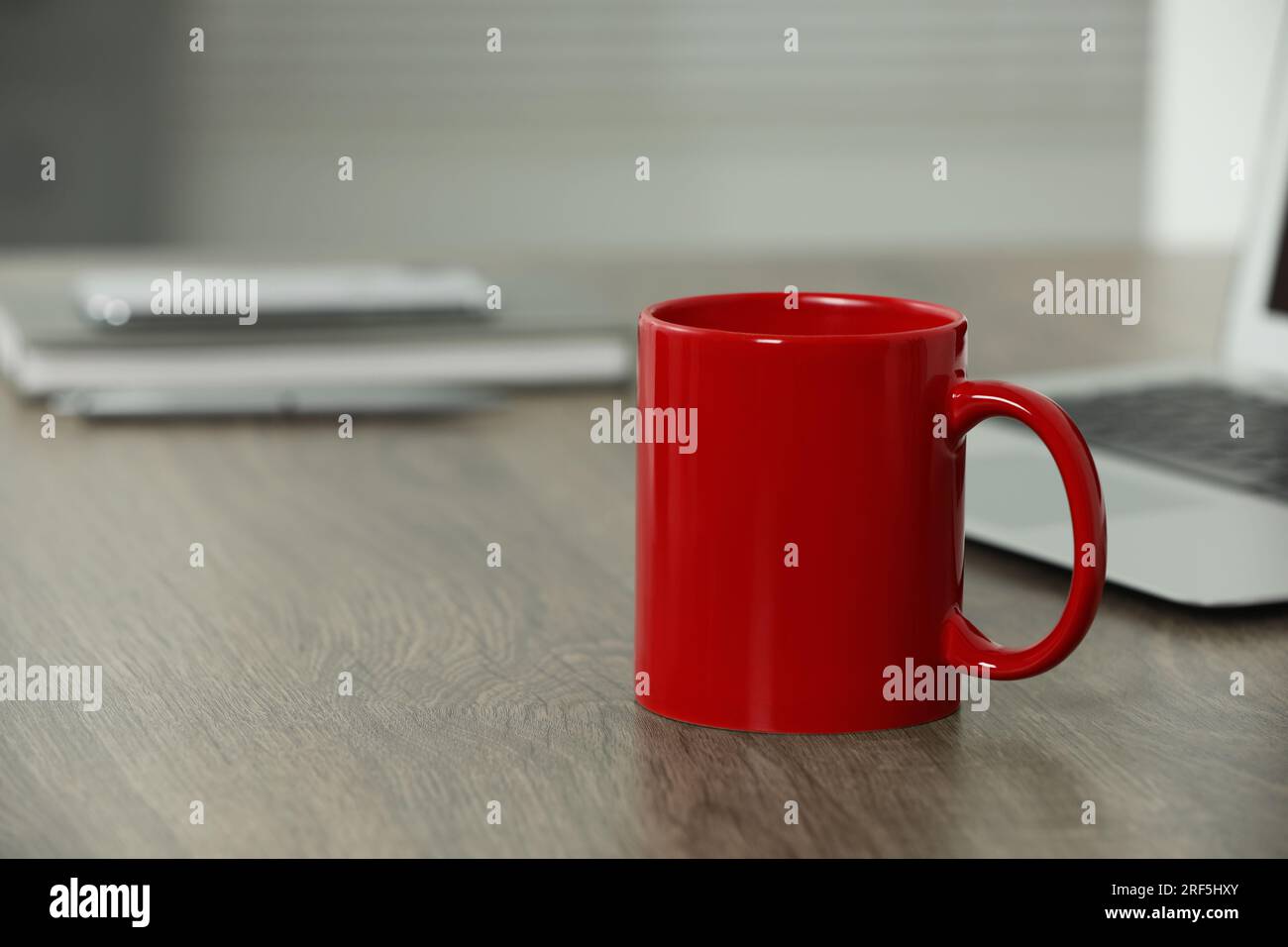 Red ceramic mug on wooden table at workplace. Mockup for design Stock ...