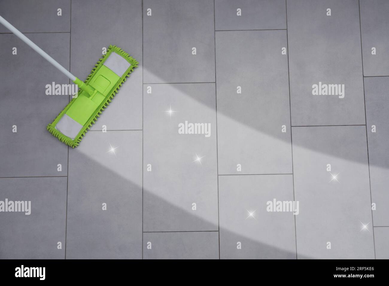 Washing floor with mop indoors, top view. Clean and shiny trace on ...