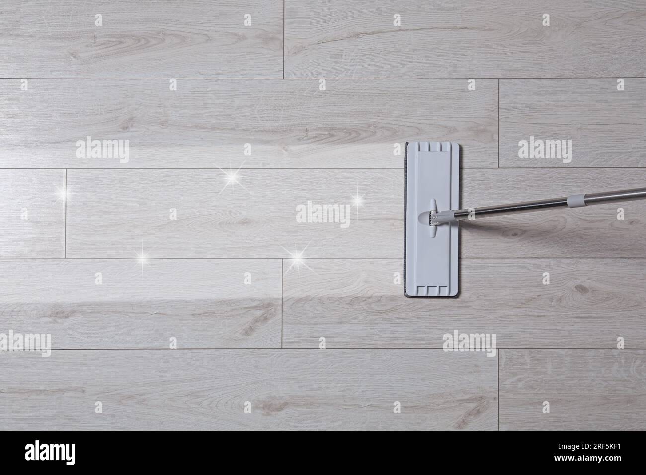 Washing floor with mop indoors, top view. Clean and shiny trace on ...