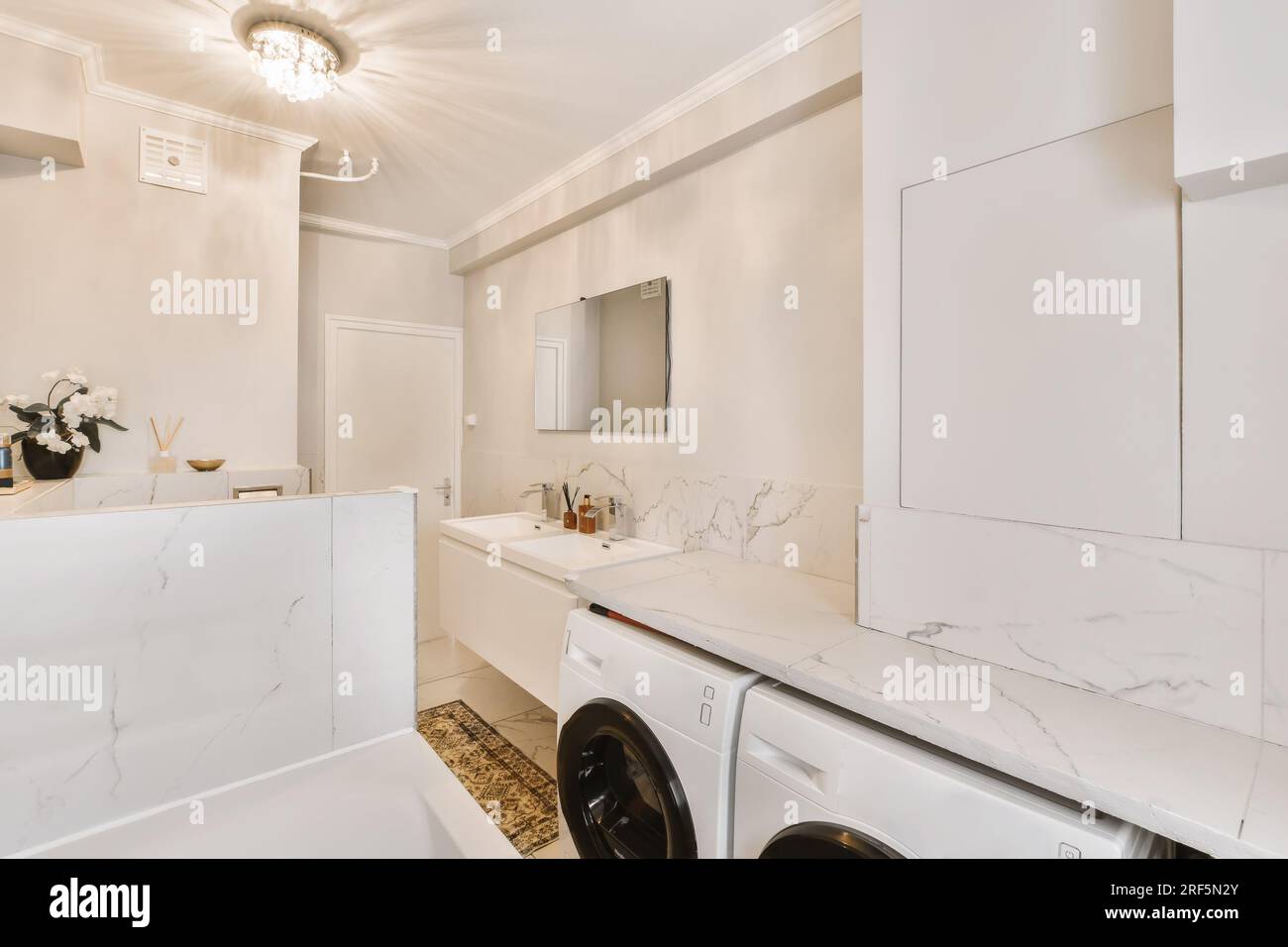 a laundry room with washer, dryer and washing machine in white marble ...