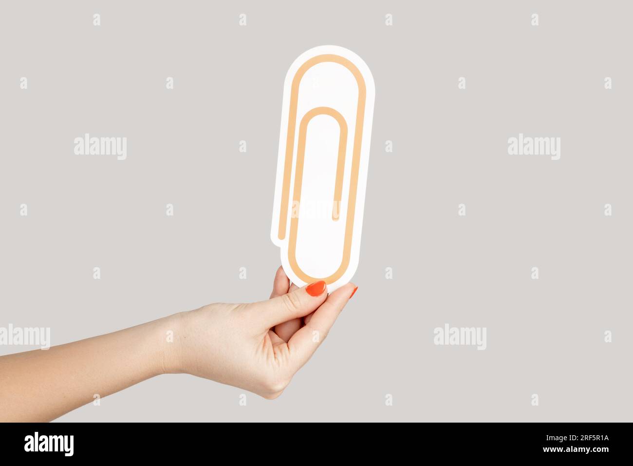 Closeup of woman hand showing paper craft clip, symbol of binding paper ...