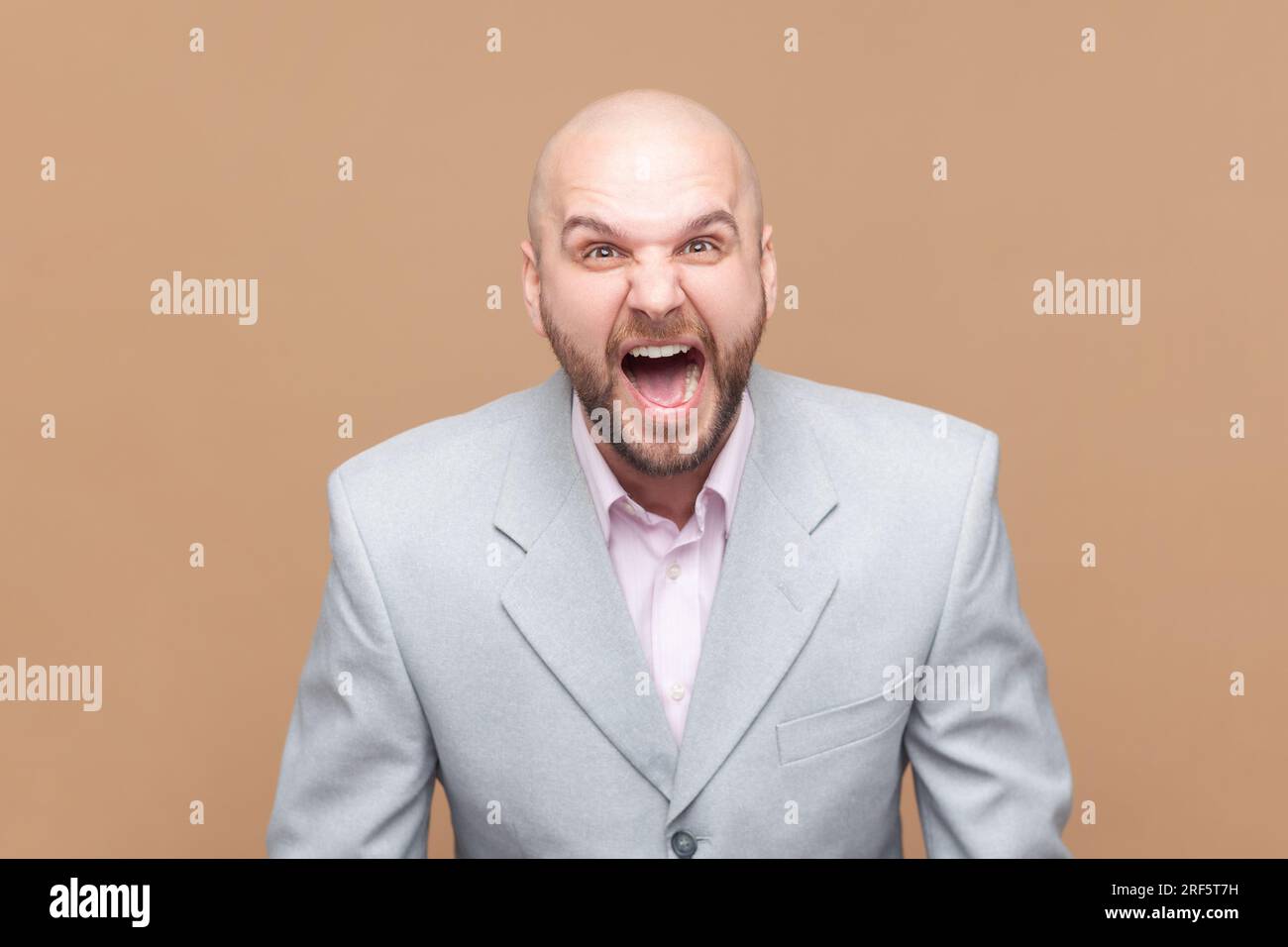Portrait of angry or shocked bald bearded man standing, looking at ...