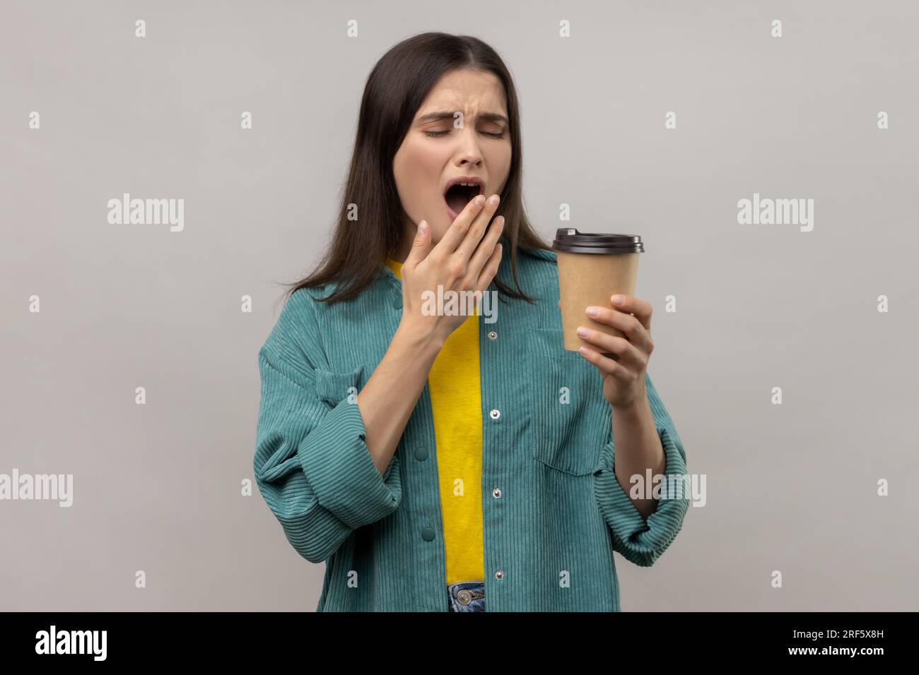 Portrait of sleepy woman holding coffee, has exhausted expression ...