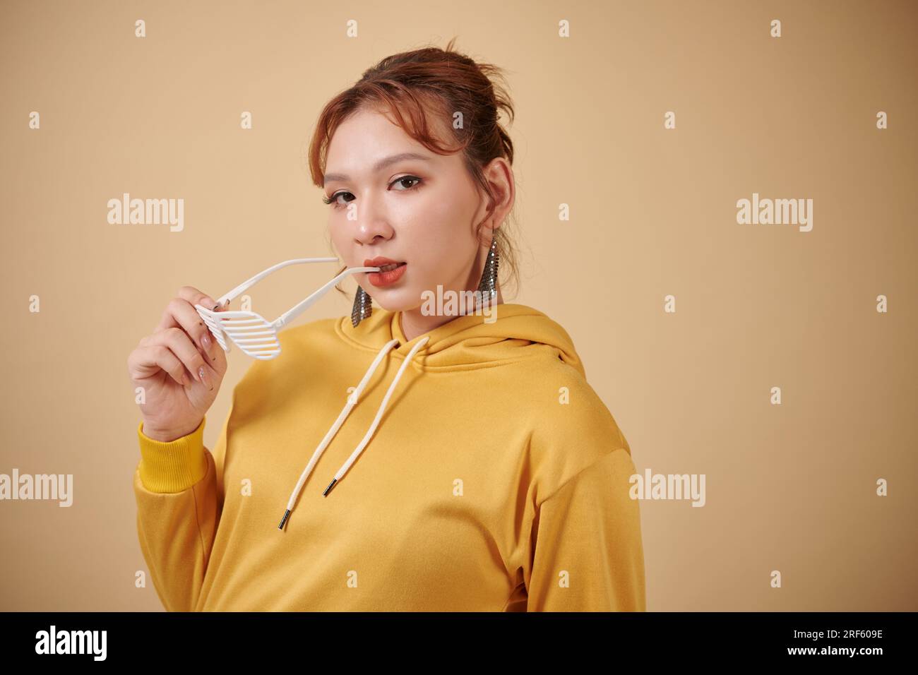 Portrait of sensual young transgender woman biting glasses frame Stock ...