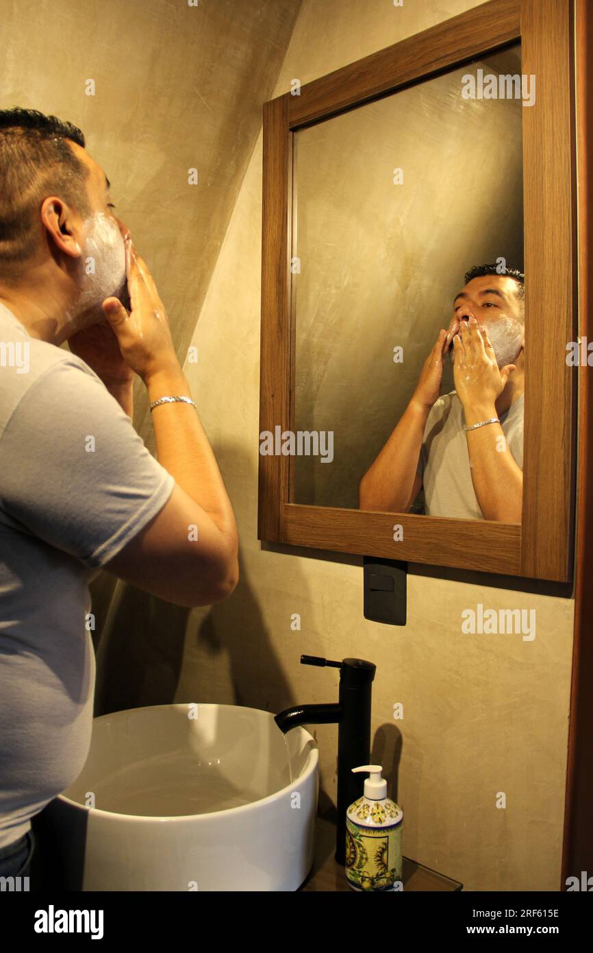 Dark-haired 40-year-old Latino man does his beauty routine, shaves with ...