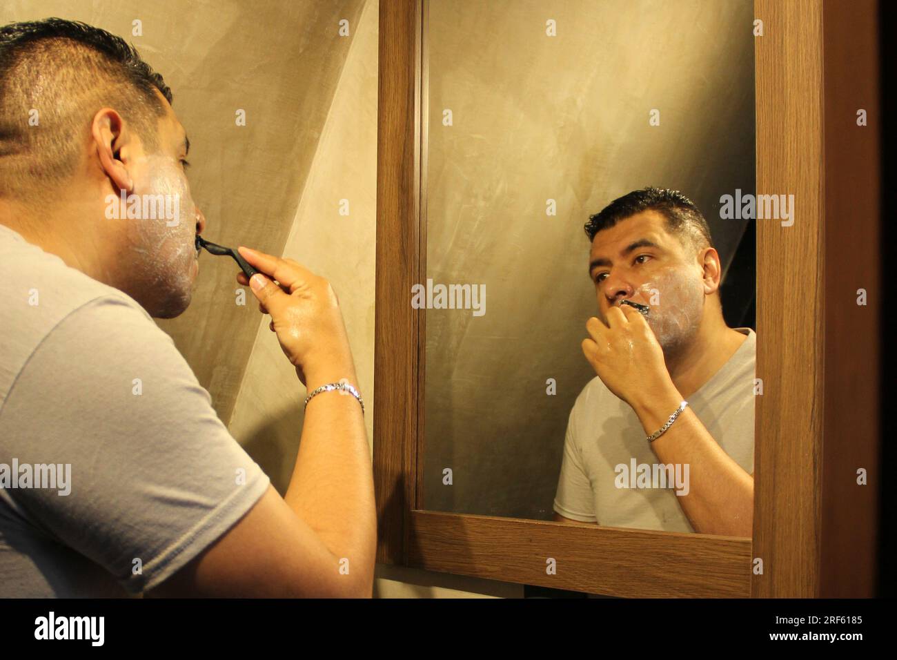 Dark-haired 40-year-old Latino man does his beauty routine, shaves with ...