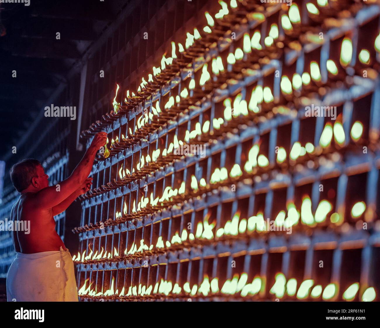 Kerala, India. 01st Aug, 2023. A Priest lighting up one of the the ...