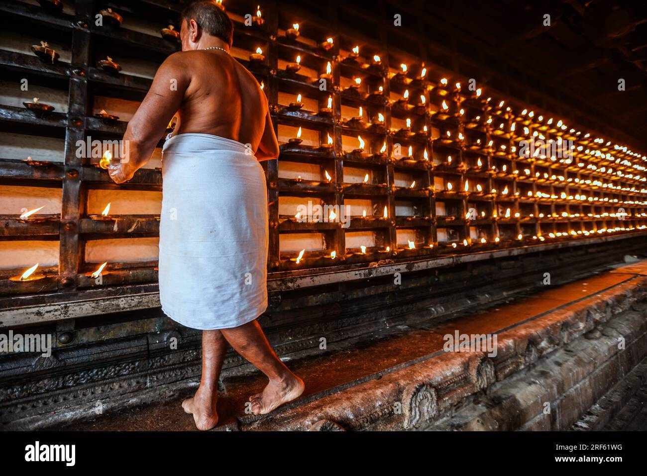 Kerala, India. 01st Aug, 2023. A Priest lighting up one of the the ...