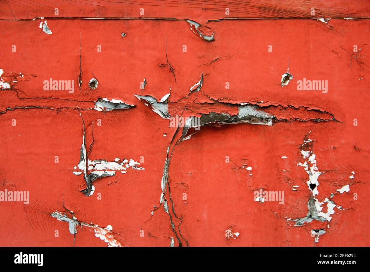 A textured red wall surface displaying the effects of erosion on the ...