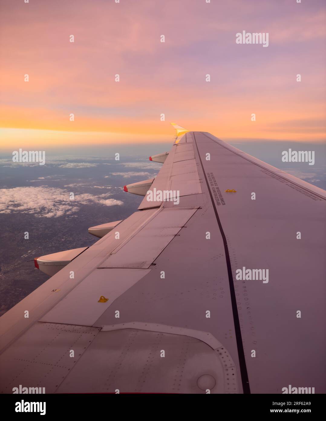 Airplane wing with sunset light while flying at altitude Stock Photo ...