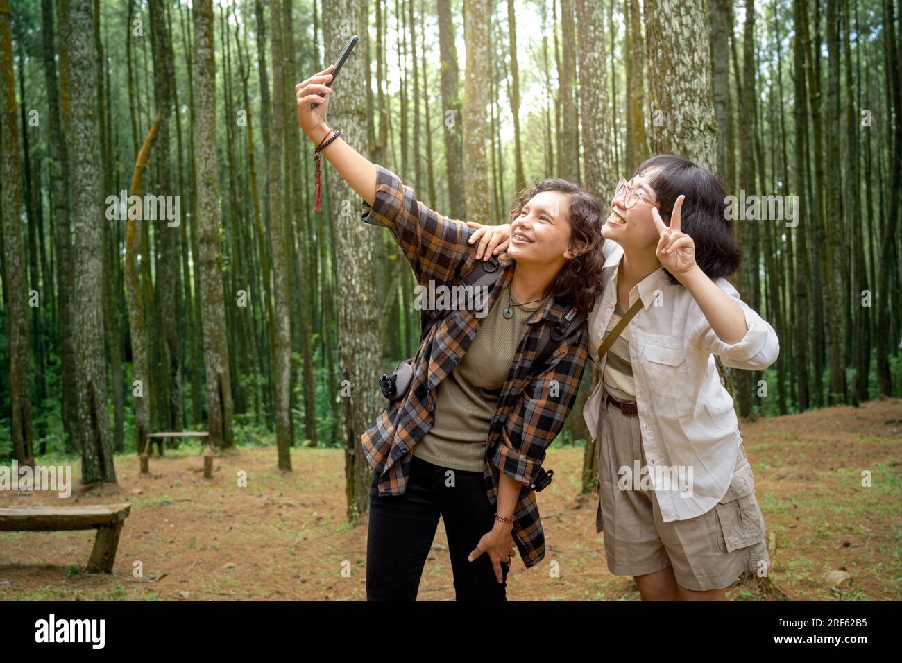 Two Asian women trekking together and taking self-portraits in the ...