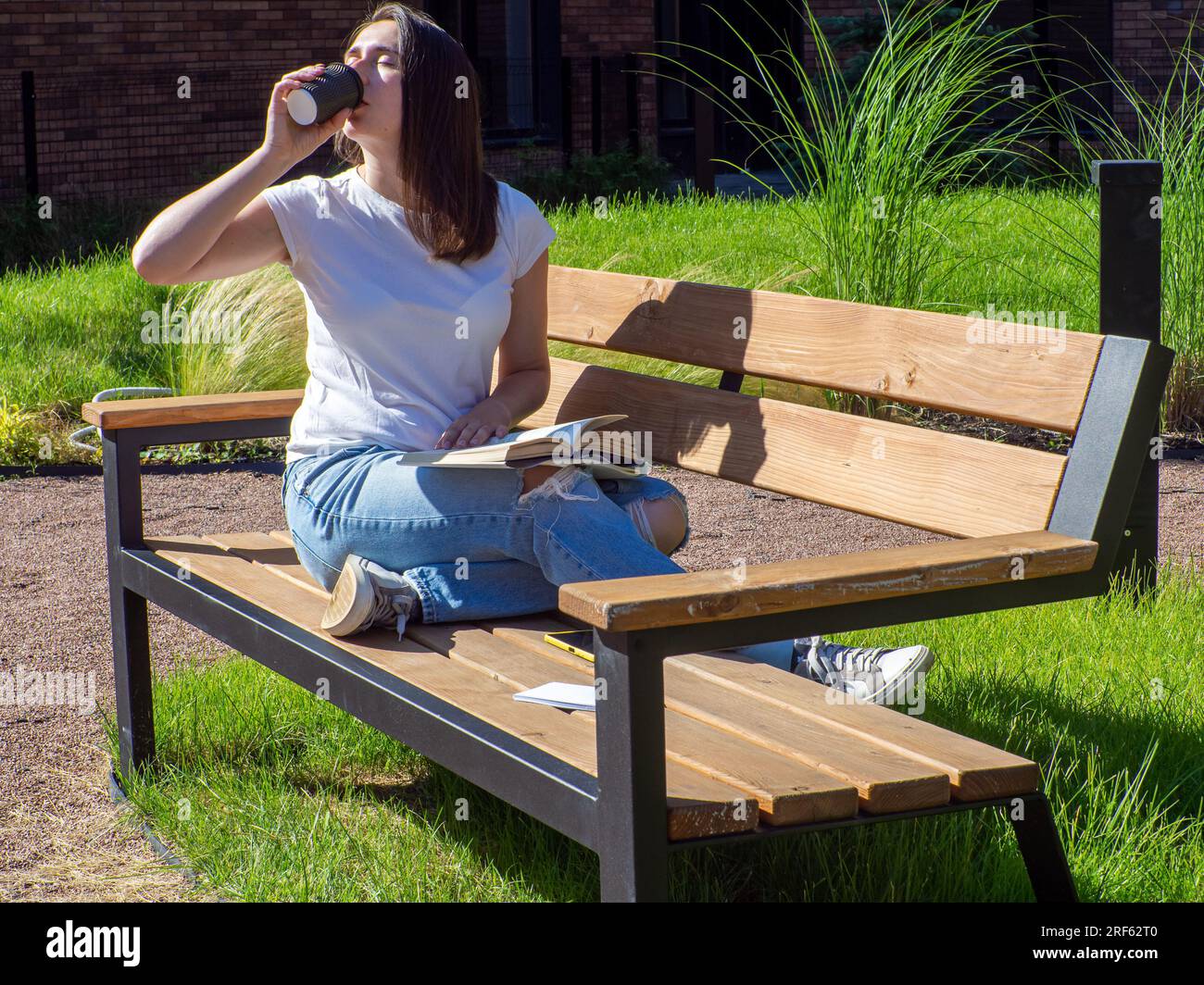 Female student studying on bench at campus Stock Photo - Alamy