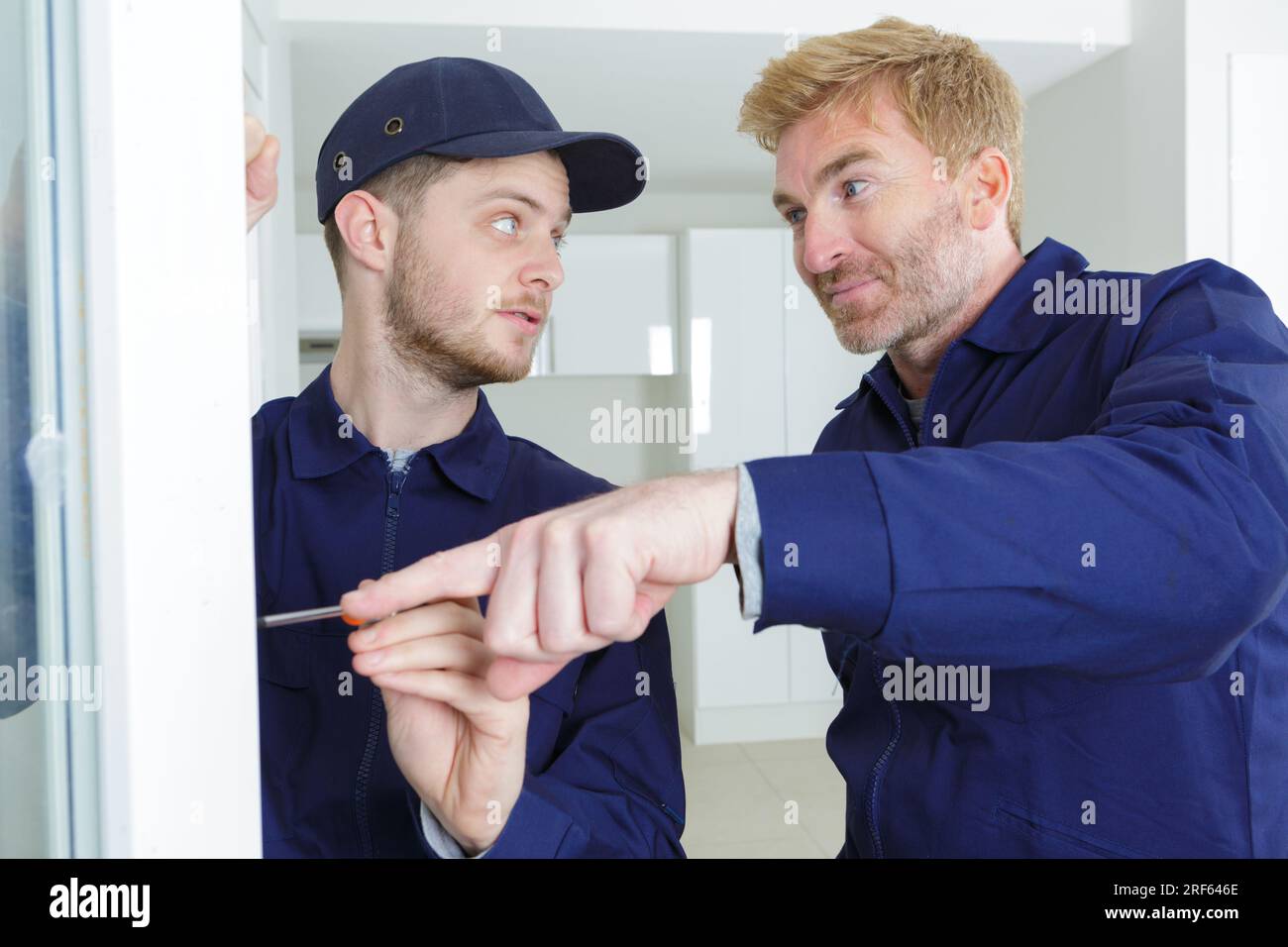 handyman in uniform fixing glass window Stock Photo - Alamy