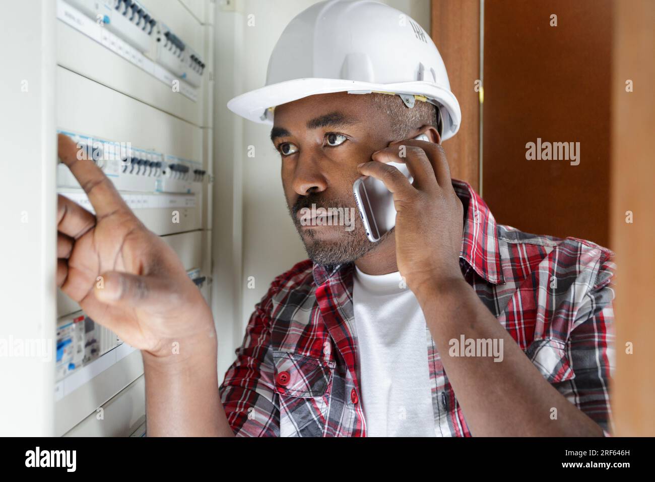 engineer talking phone while checking fuse board Stock Photo - Alamy