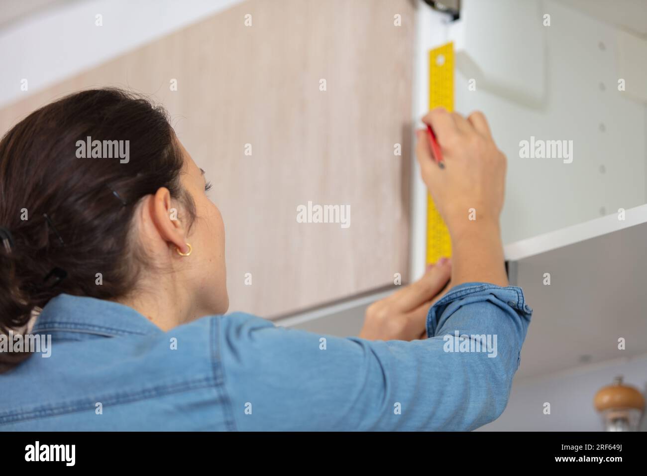 woman using spirit level and pencil marking shelf Stock Photo - Alamy